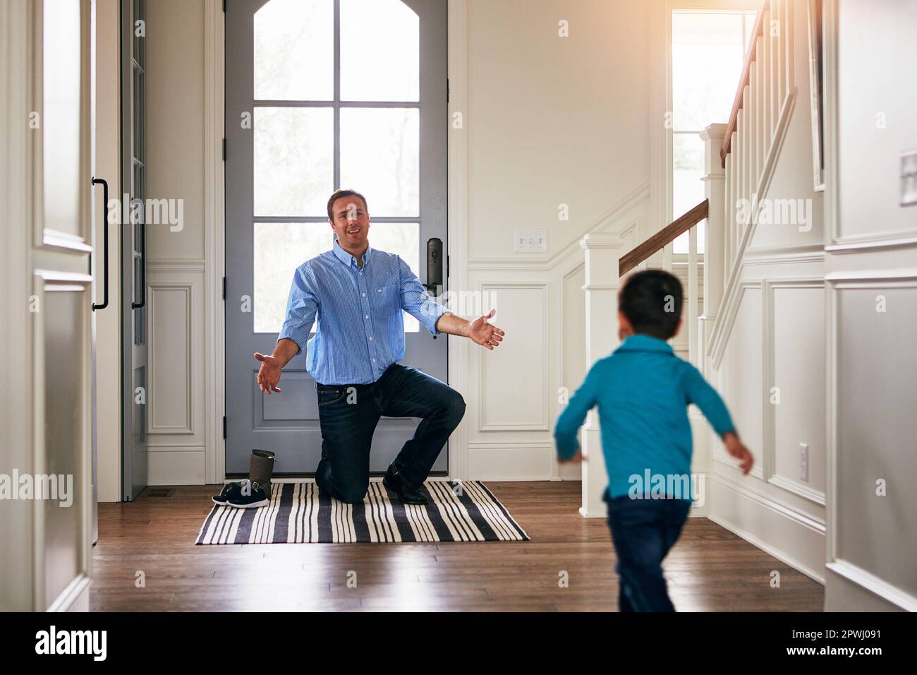 My boy. a father arriving home to a loving welcome from his son Stock ...