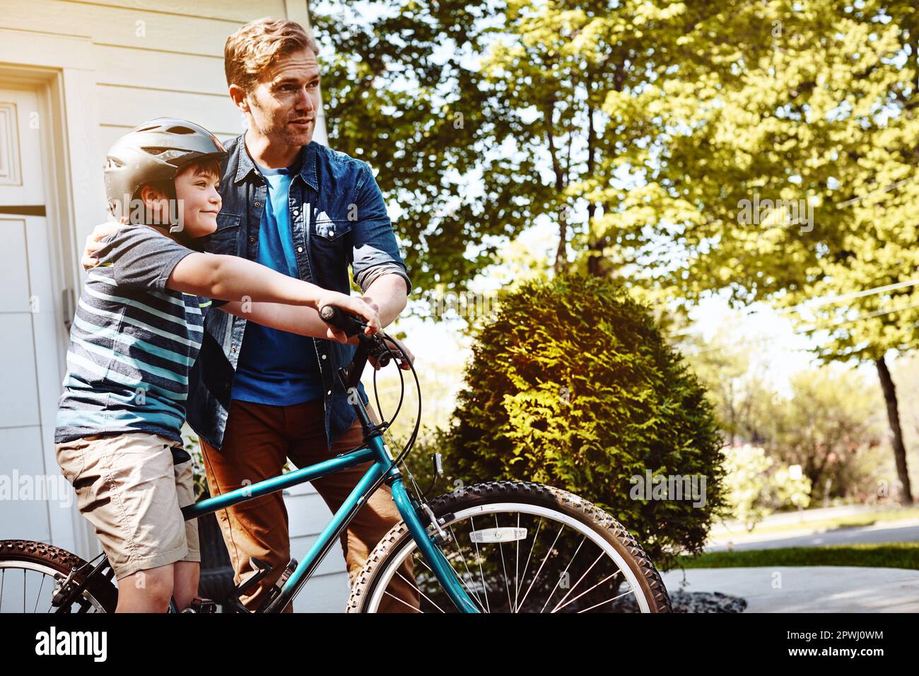 Learning a new skill with Dad. a father teaching his son how to ride a ...