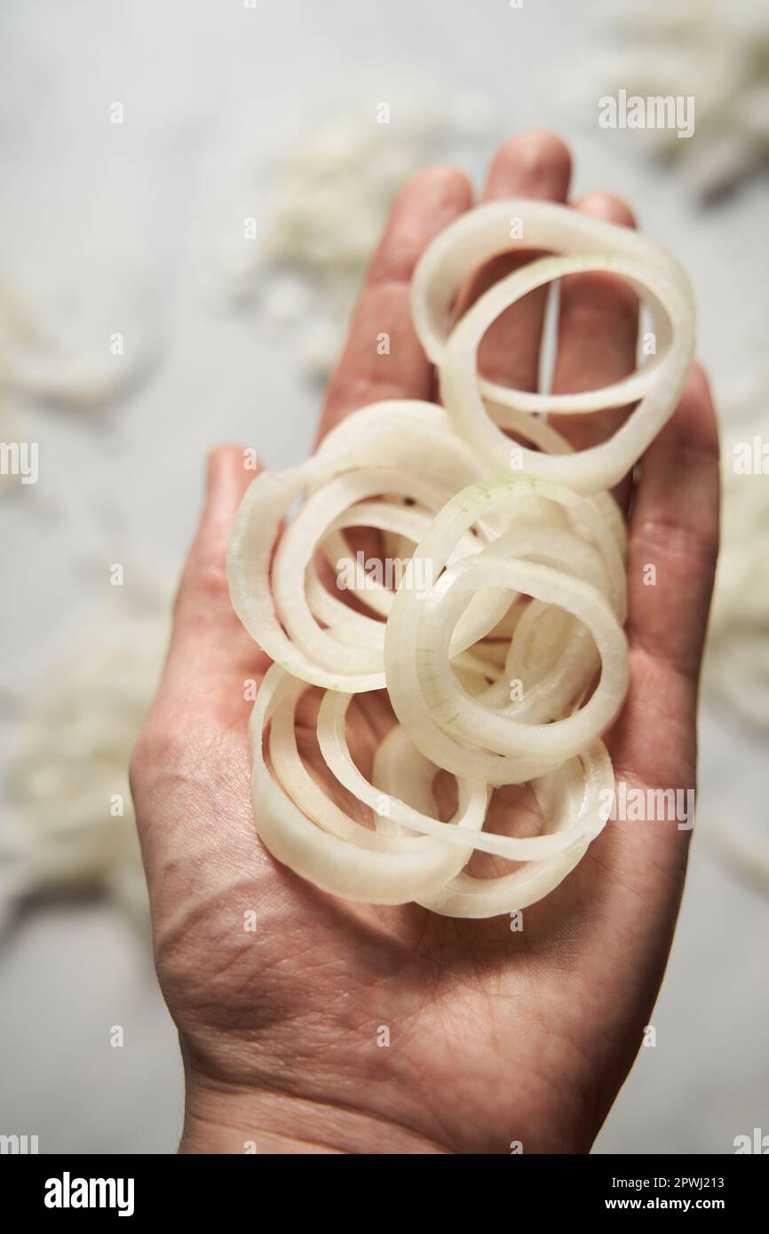 Ring sliced onions on mans hand. Photo show how does onion sliced into ...