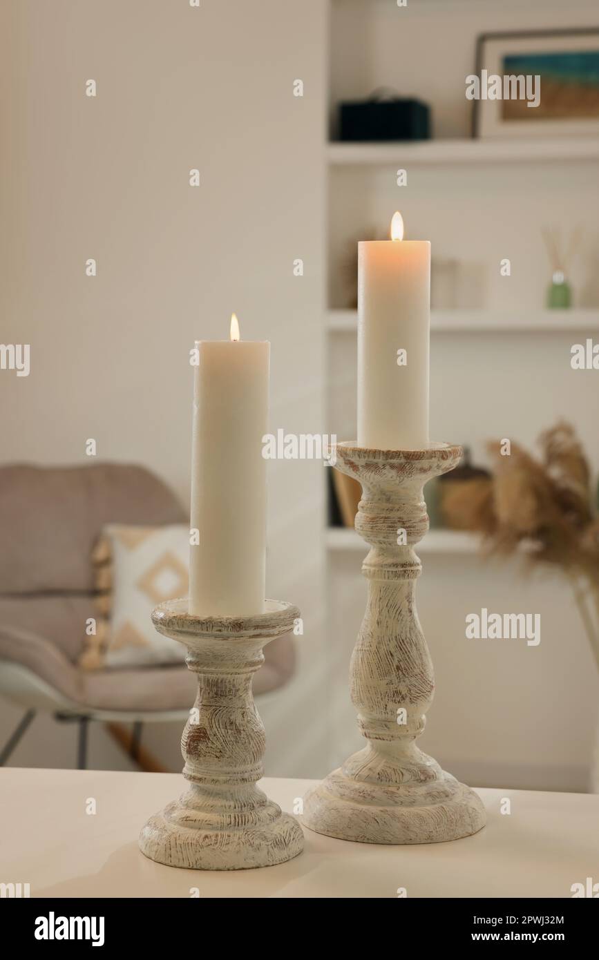 Beautiful wooden candlesticks on white table in room Stock Photo - Alamy