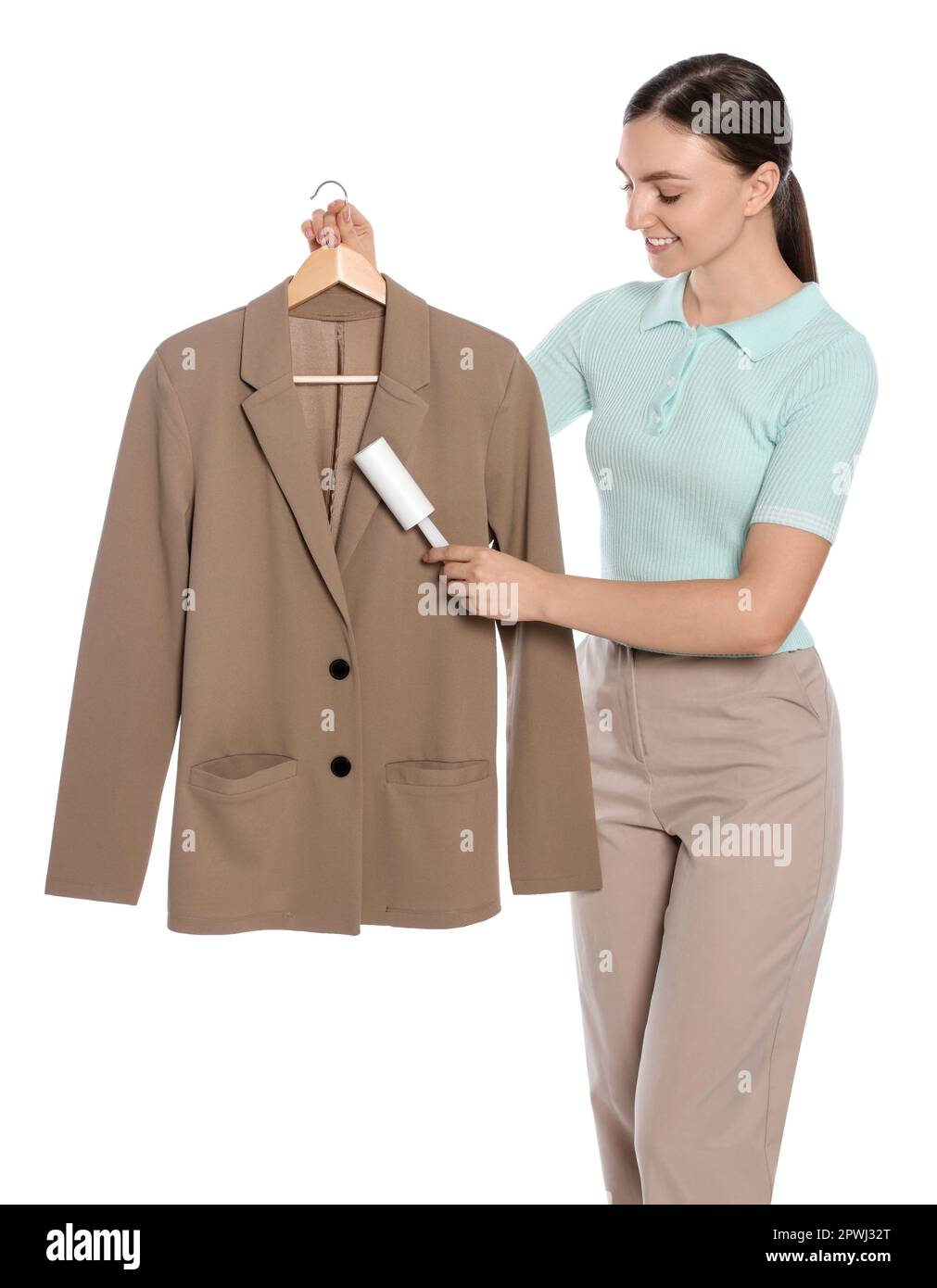 Young woman cleaning suit with lint roller on white background Stock ...