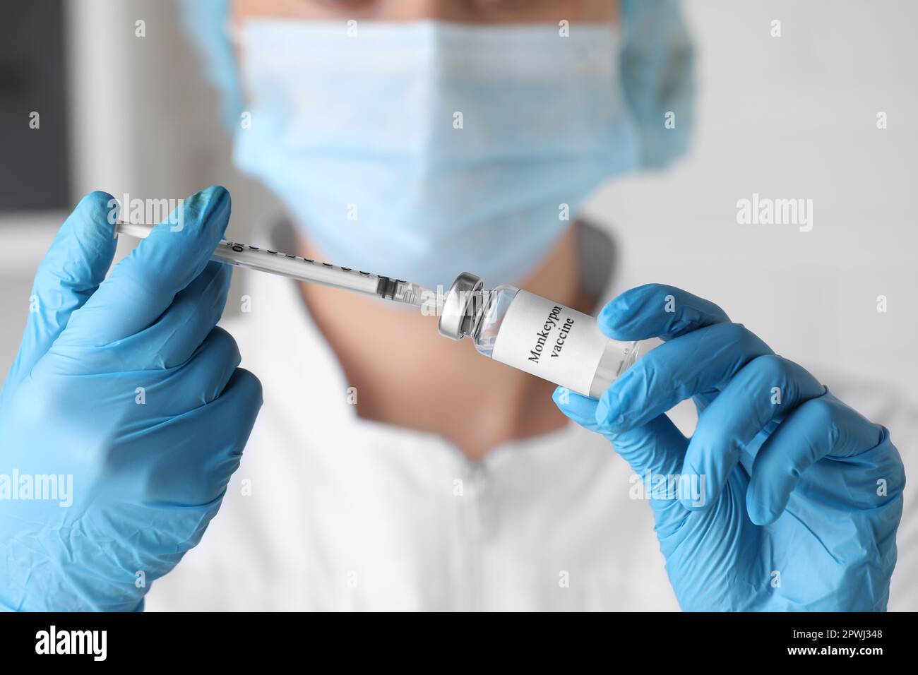 Nurse filling syringe with monkeypox vaccine from glass vial in ...