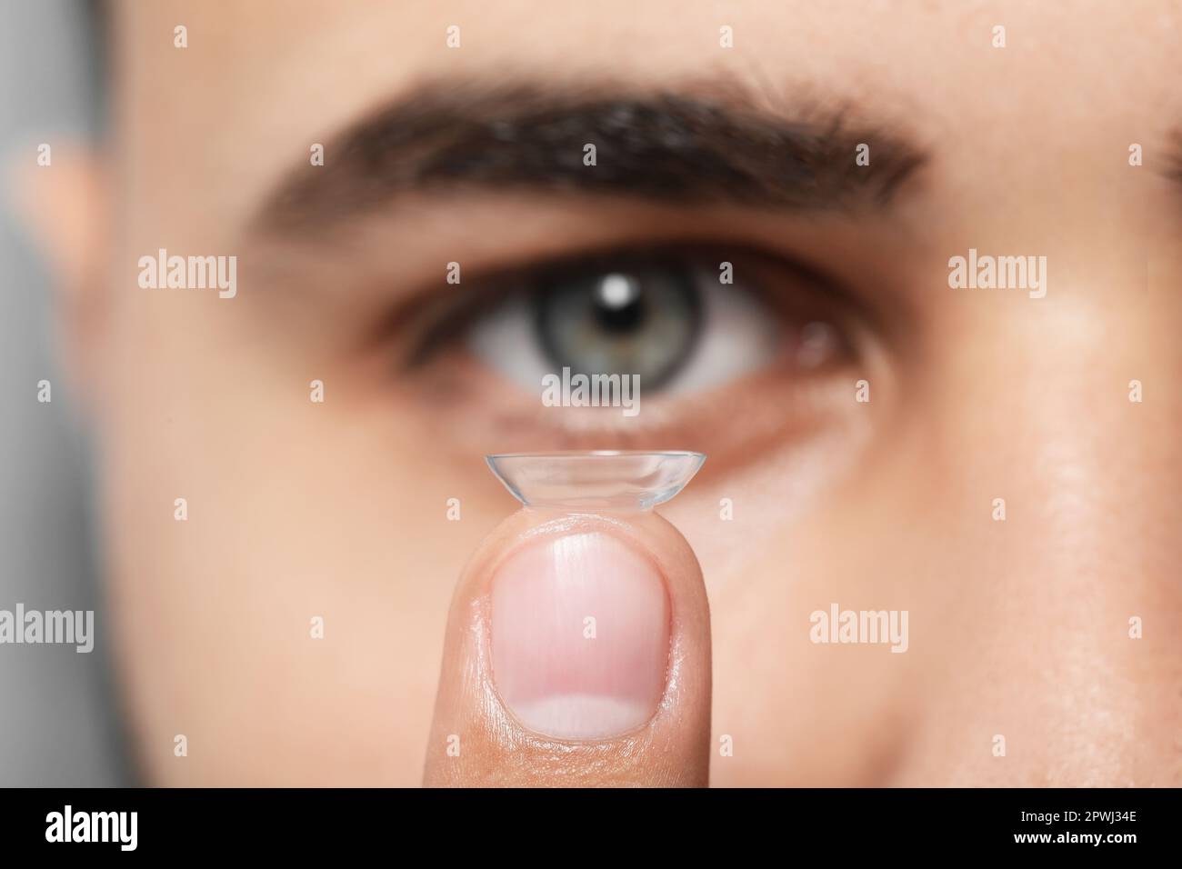 Young man with contact lens, focus on finger Stock Photo - Alamy