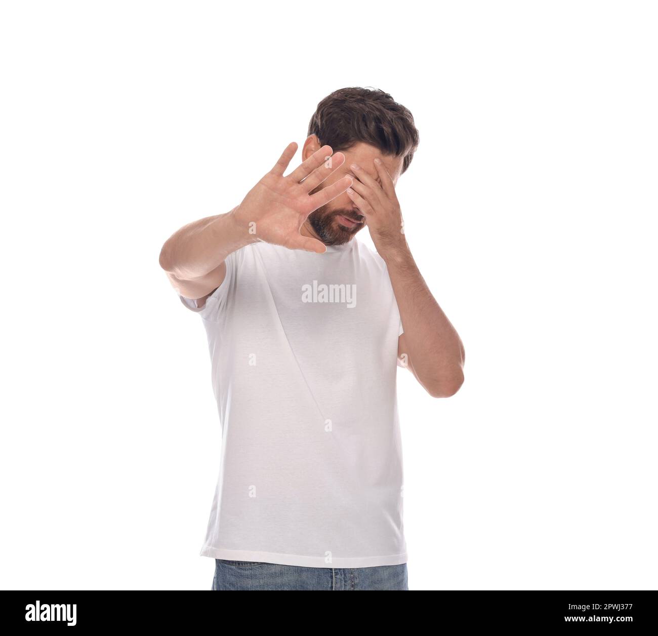 Embarrassed man covering face with hands on white background Stock ...