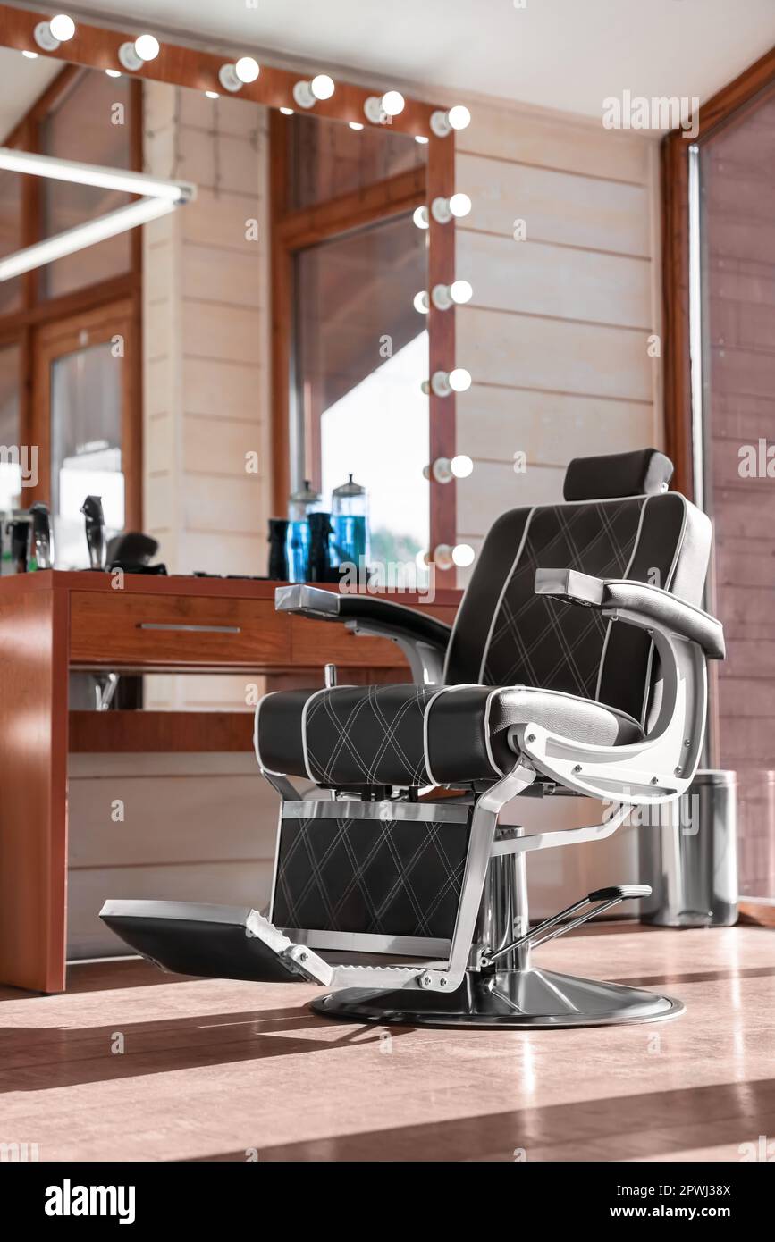 Stylish hairdresser's workplace with professional armchair and large ...