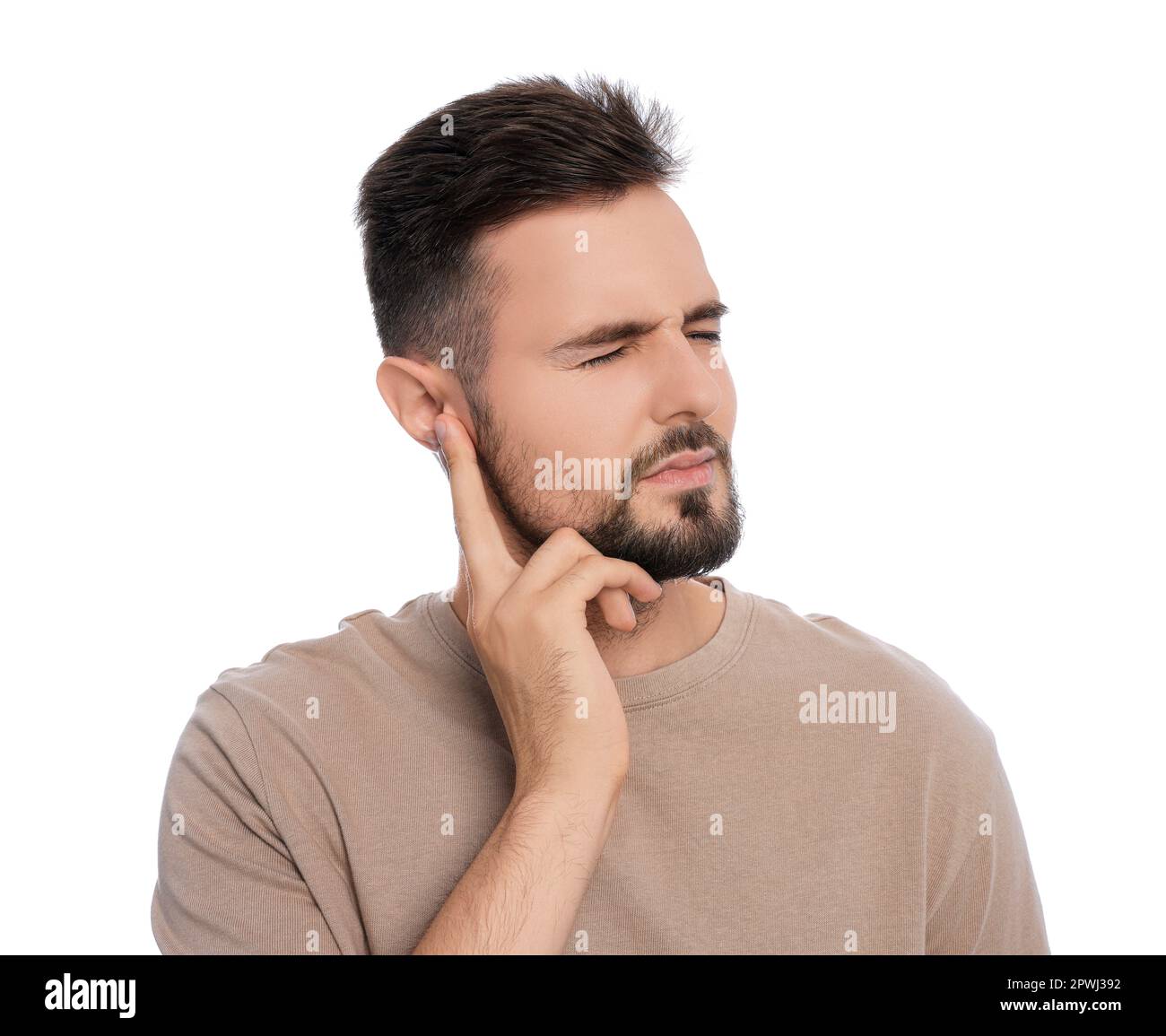 Young man suffering from ear pain on white background Stock Photo - Alamy