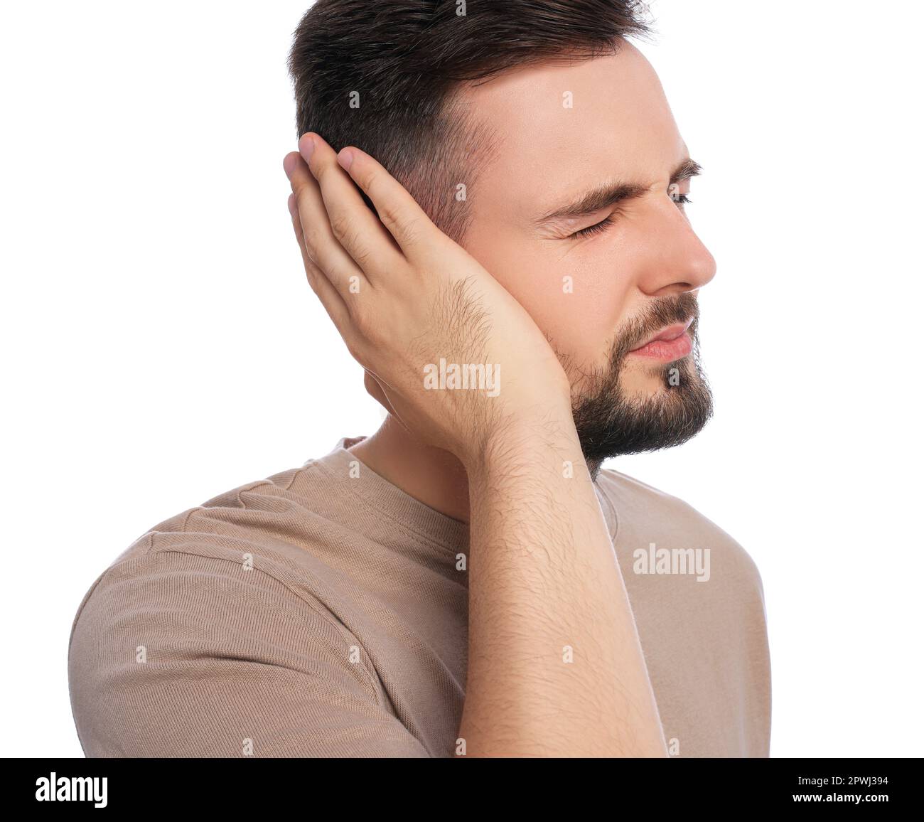 Young man suffering from ear pain on white background Stock Photo - Alamy