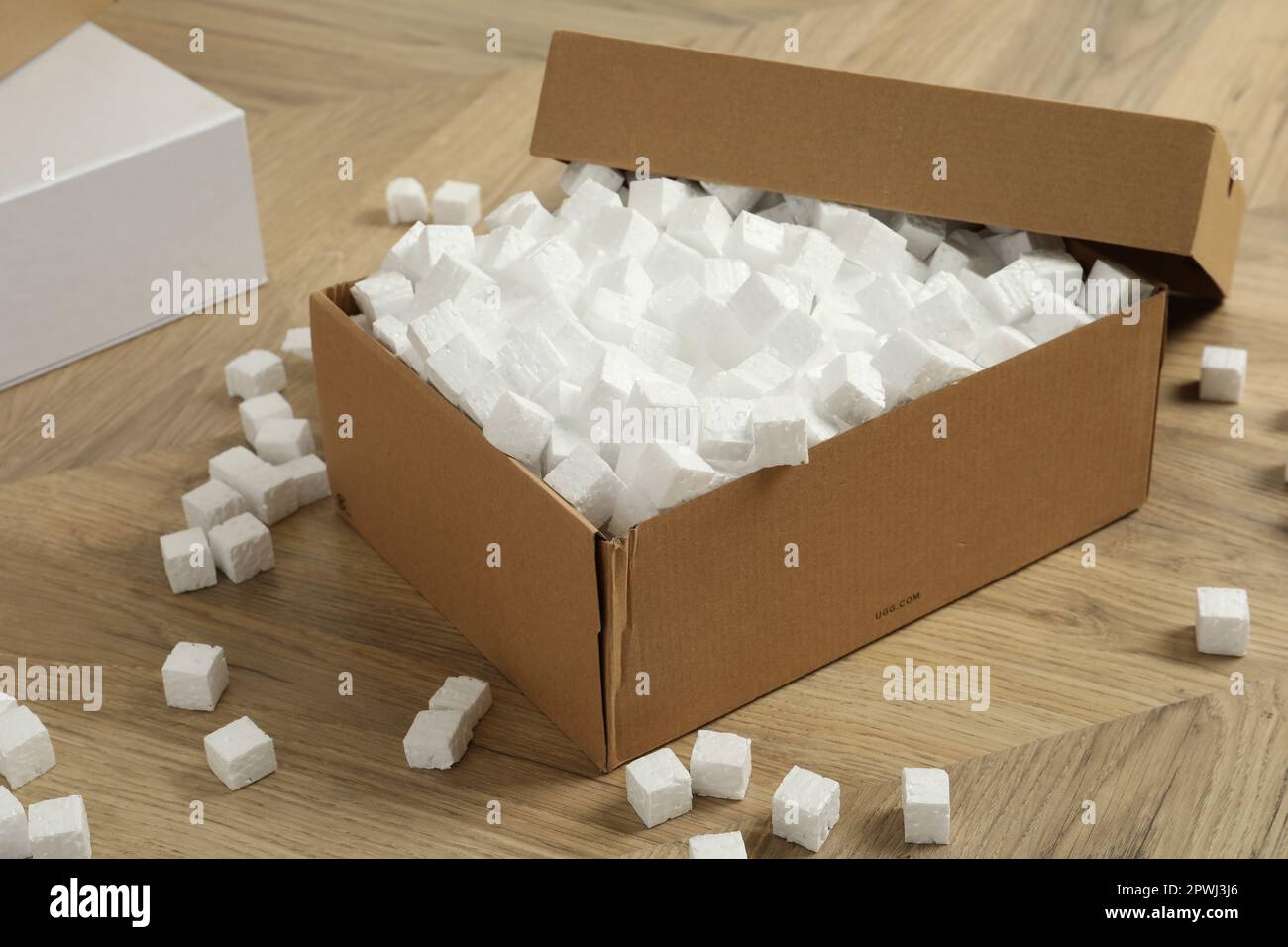 Cardboard box and styrofoam cubes on wooden floor Stock Photo - Alamy