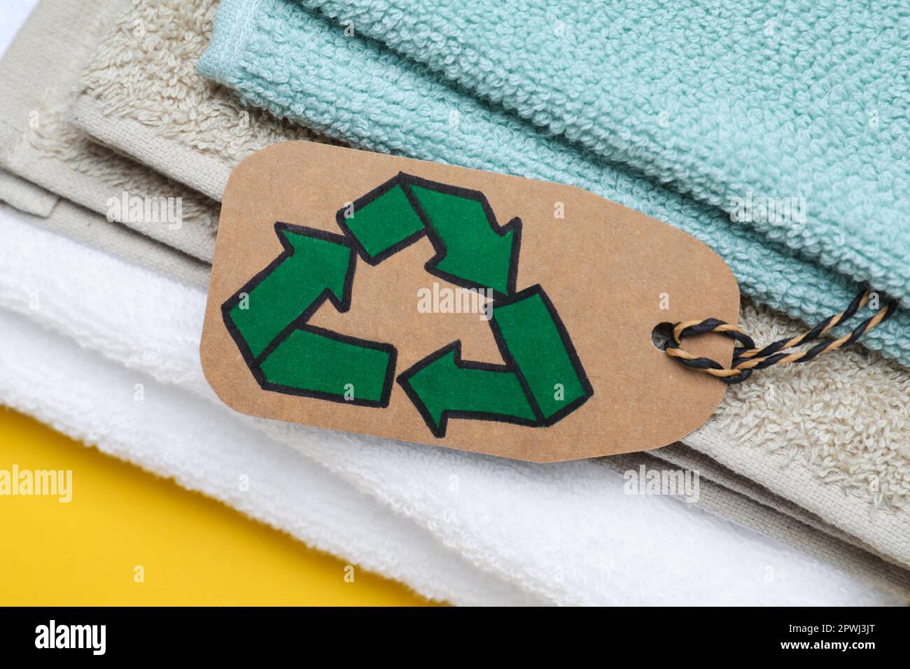 Stacked towels with recycling label, closeup view Stock Photo - Alamy