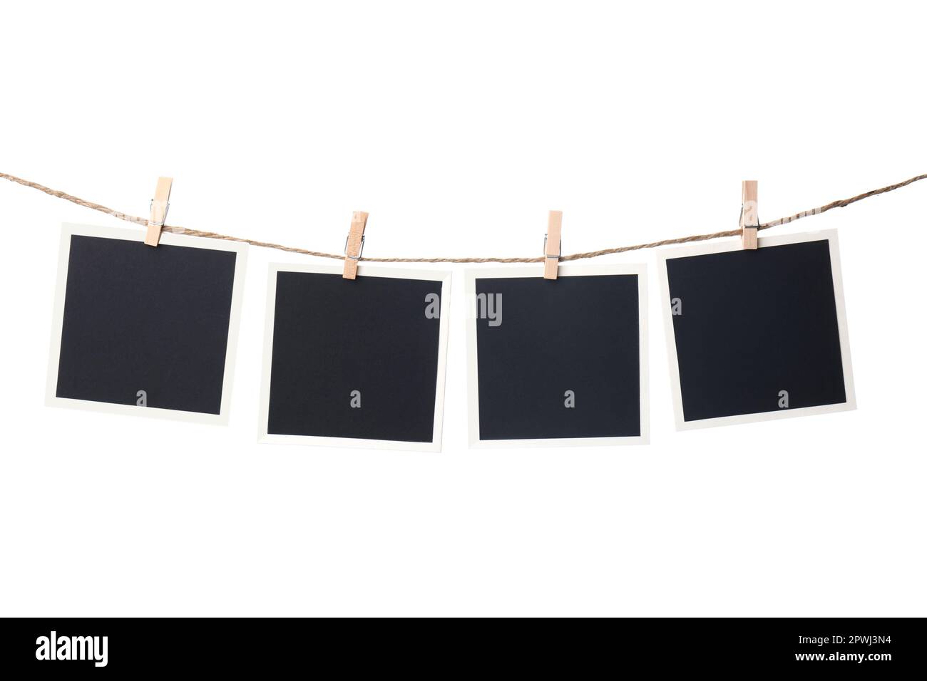 Clothespins with empty instant frames on string against white ...