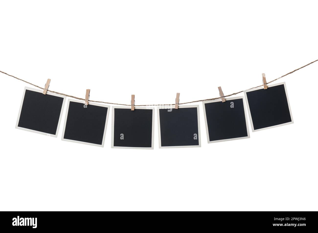 Clothespins with empty instant frames on string against white ...
