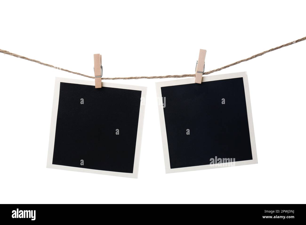 Clothespins with empty instant frames on string against white ...