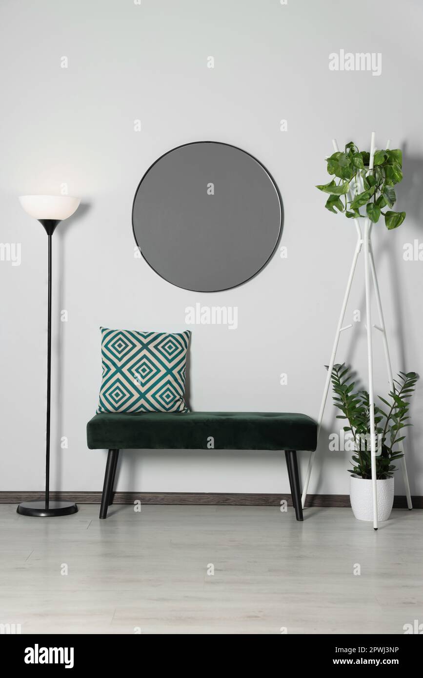 Stylish round mirror on white wall over bench in room Stock Photo - Alamy