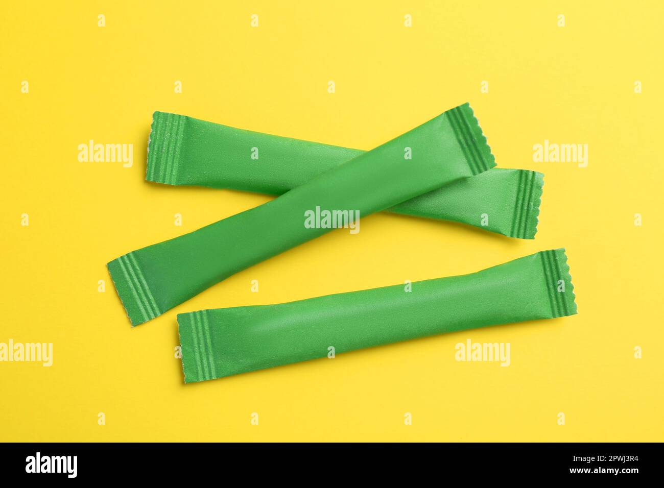 Green sticks of sugar on yellow background, flat lay Stock Photo - Alamy