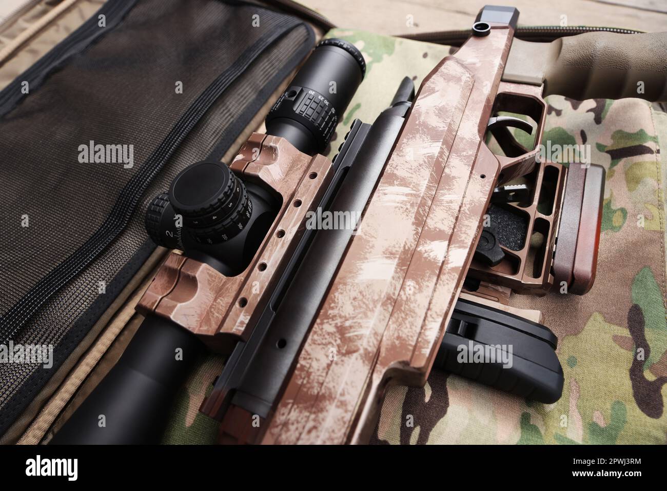 Modern powerful sniper rifle with telescopic sight on camouflage fabric ...
