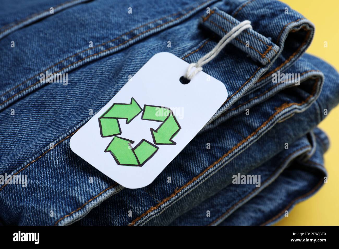 Folded jeans with recycling label, closeup view Stock Photo - Alamy