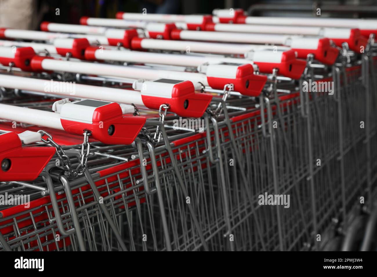 Many empty metal shopping carts near supermarket outdoors, closeup ...