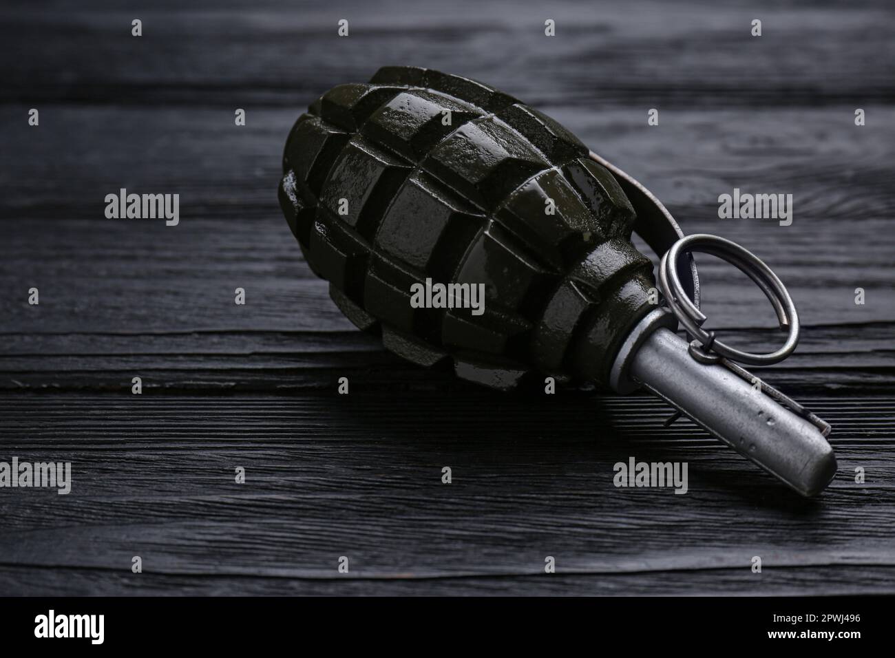 Hand grenade on black wooden table, closeup. Explosive weapon Stock ...