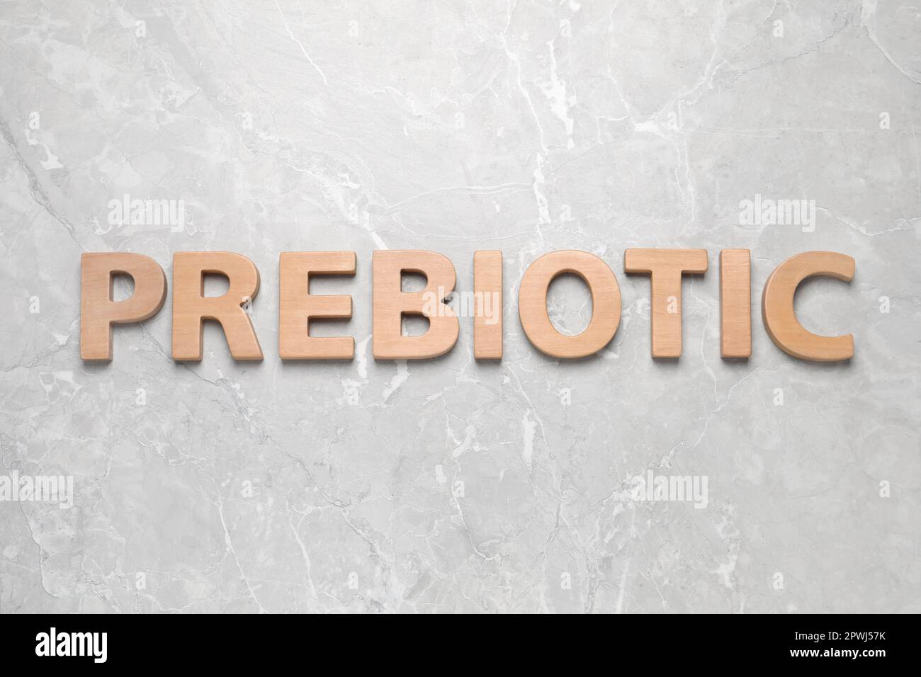 Word Prebiotic made of wooden letters on light grey marble table, flat ...