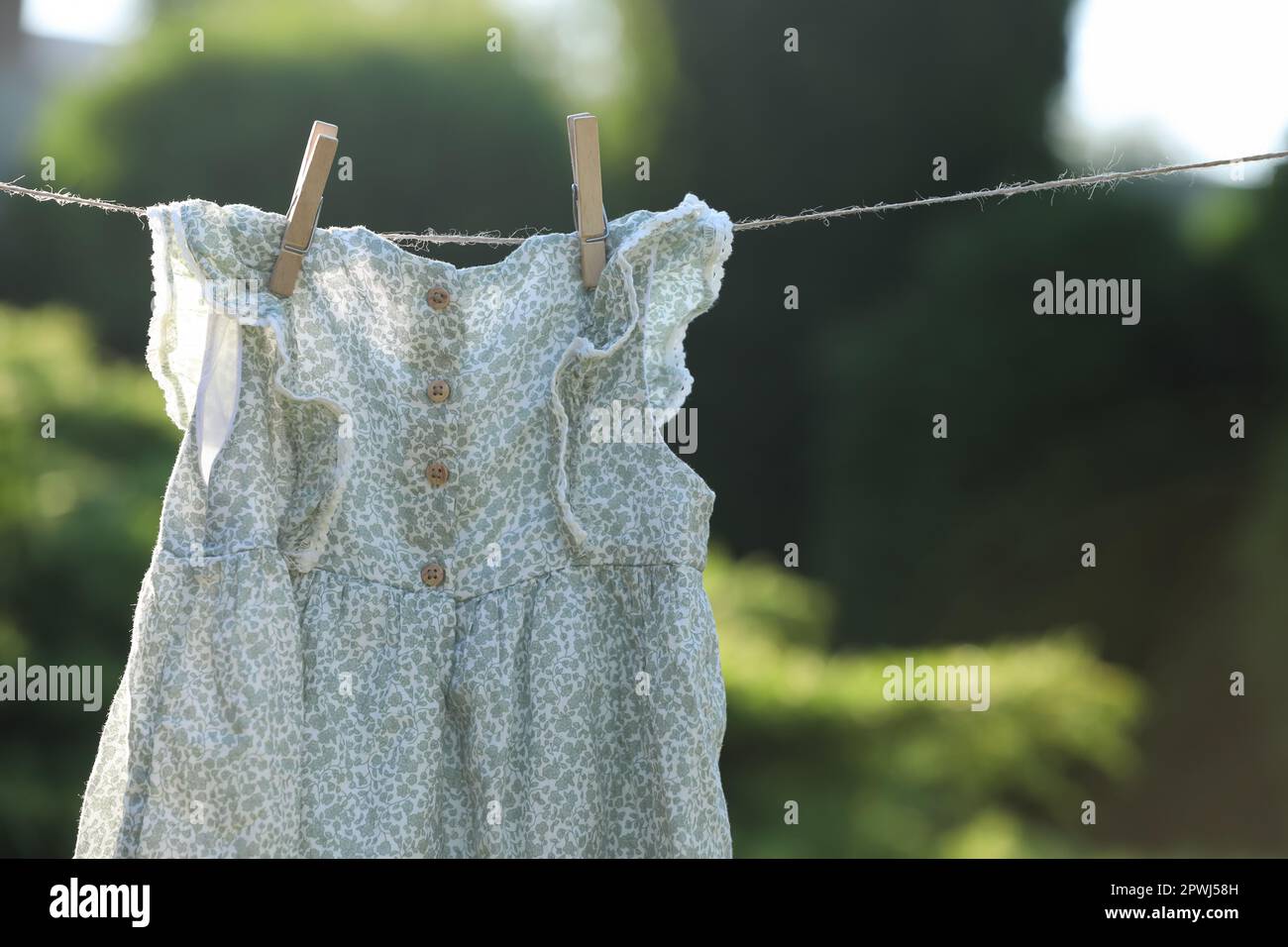 Dress drying on washing line against blurred background Stock Photo - Alamy