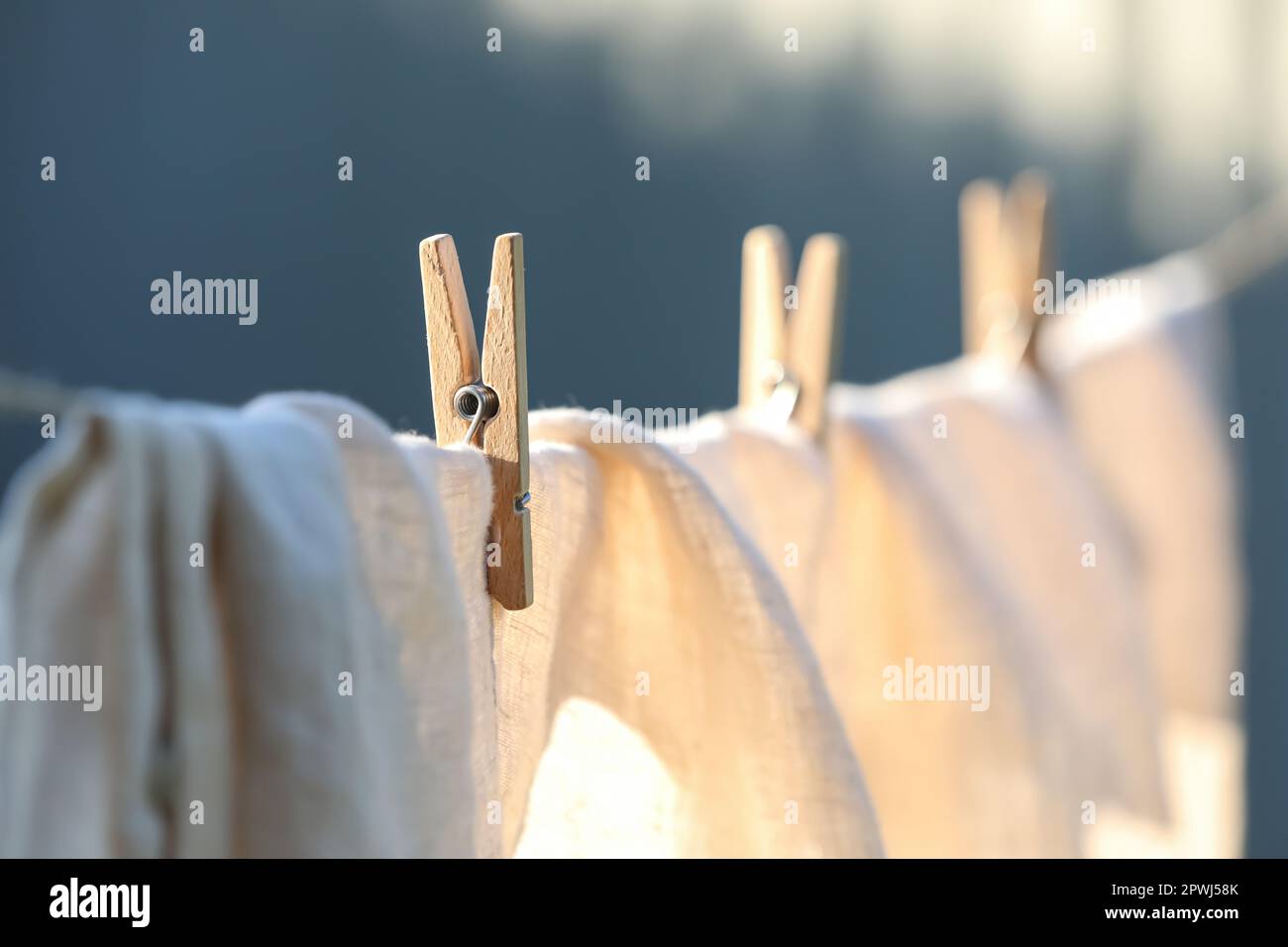 Washing line with drying shirt against blurred background, focus on ...