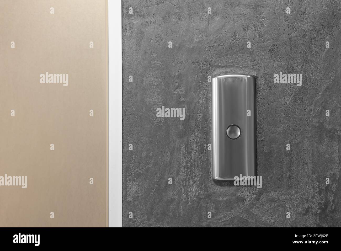 Elevator call button on grey textured wall Stock Photo - Alamy