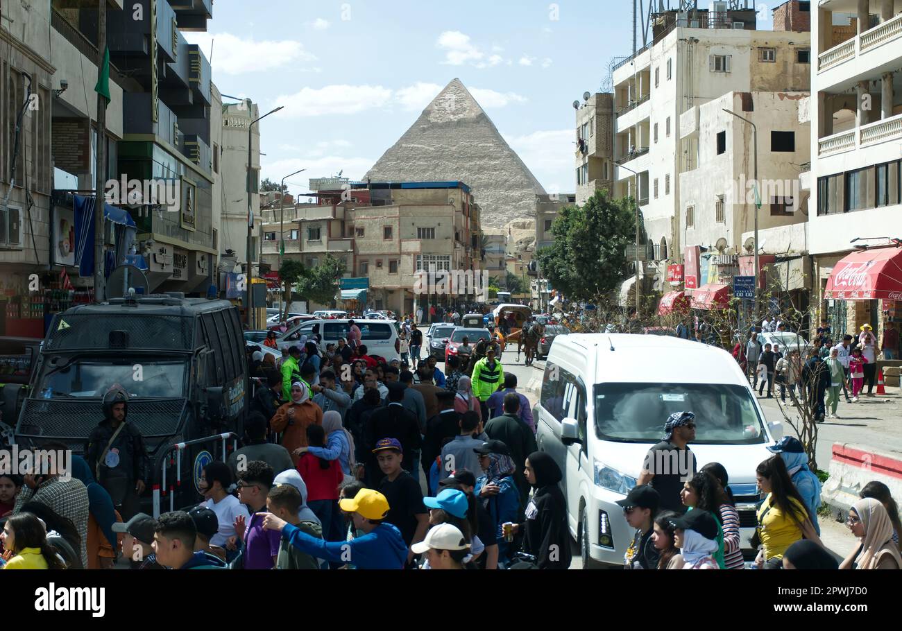 People and traffic in Cairo, pyramid of Khafre (Chephren) on background ...
