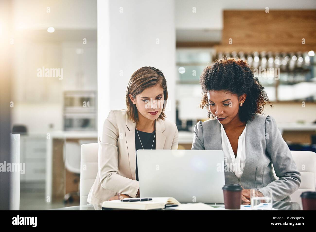 Working hard together to achieve big together. two businesswomen ...