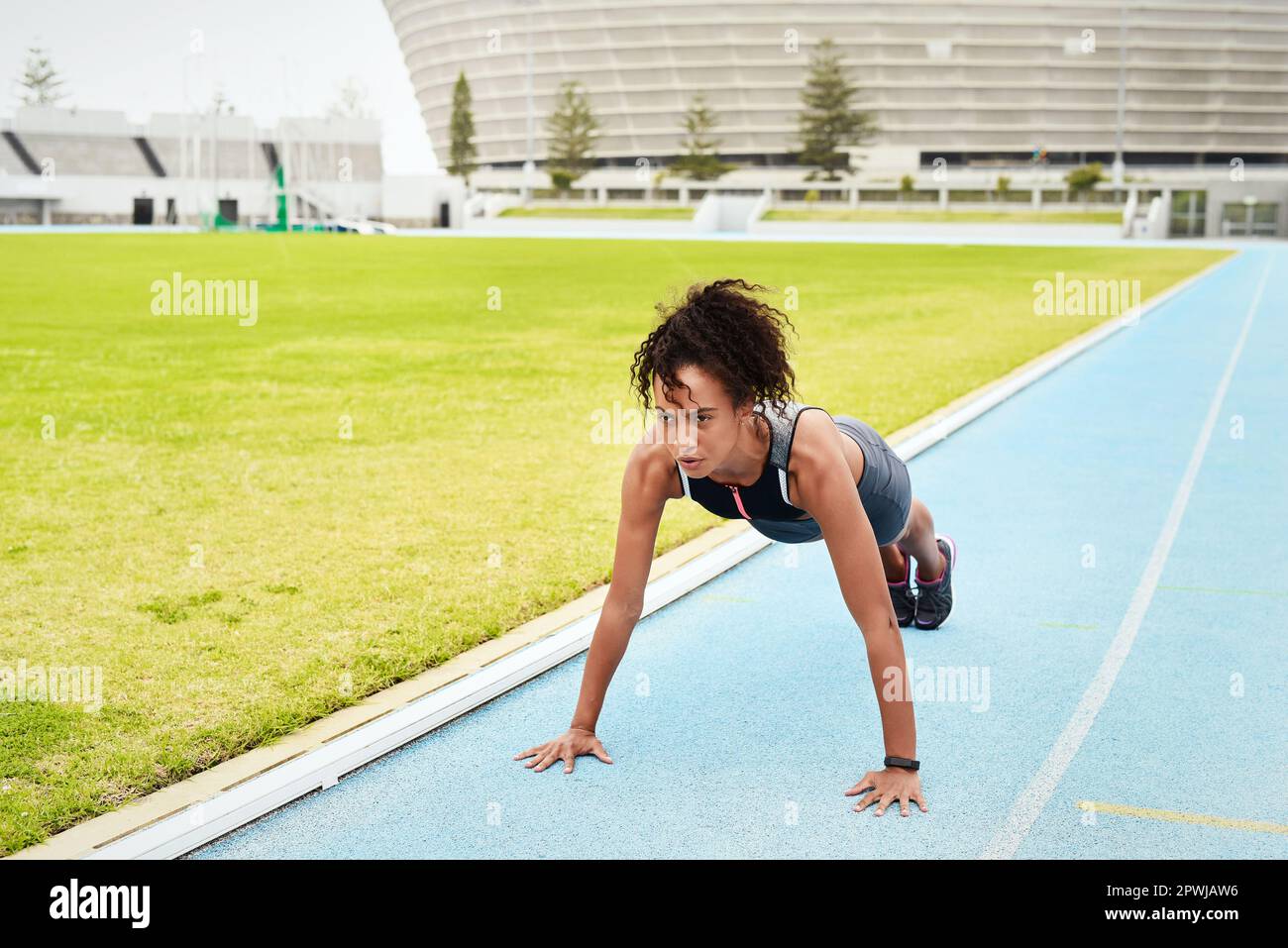 Going from strength to strength. Full length shot of an attractive young female athlete planking ...