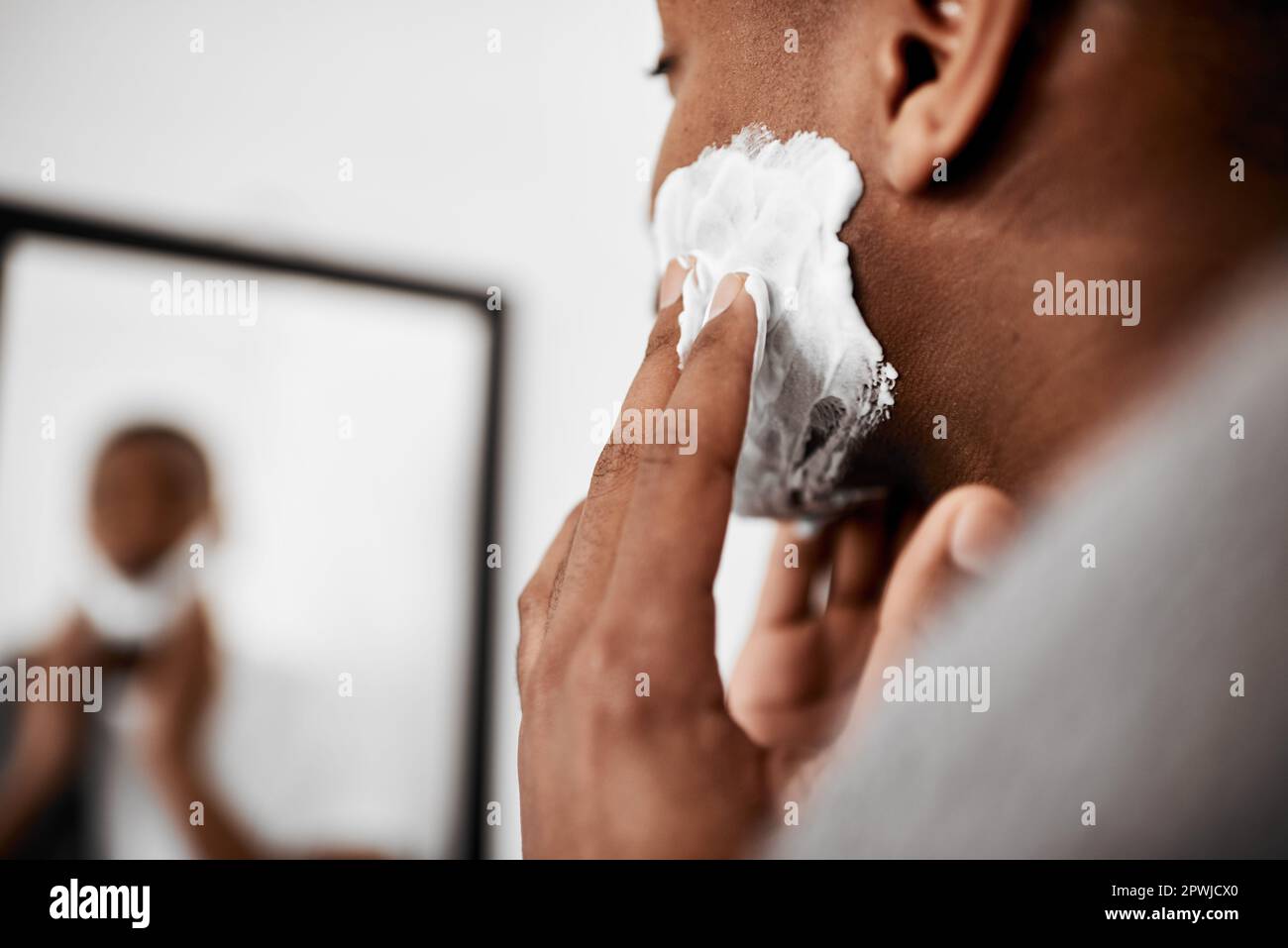 Getting ready to shave. a young man applying shaving foam to his face Stock Photo - Alamy