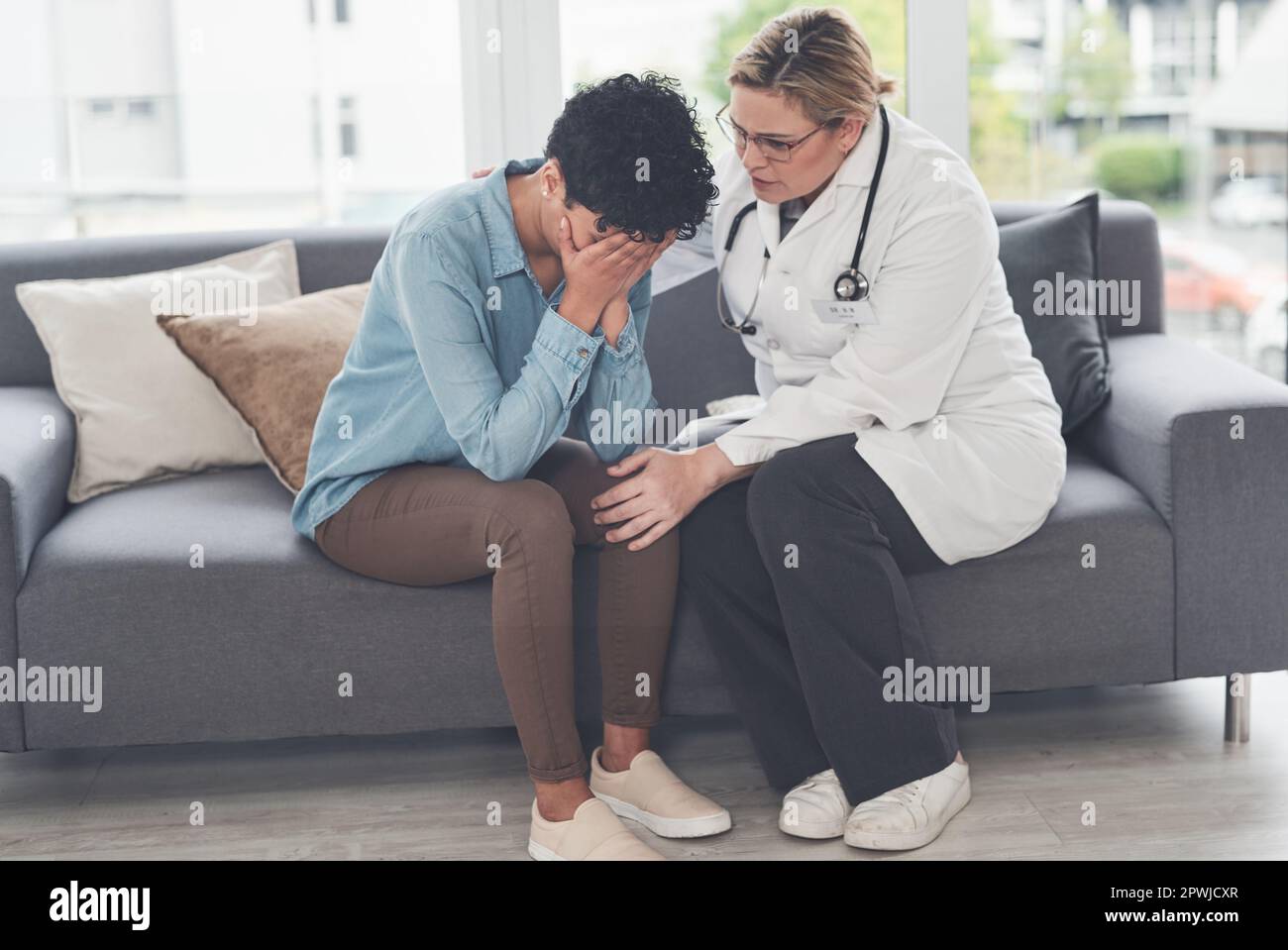 Doctor consoling stress women hi-res stock photography and images - Alamy