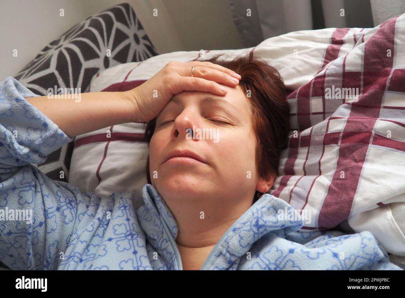 Sick woman in bed. Headache, runny nose and cold. Paleness of the face ...