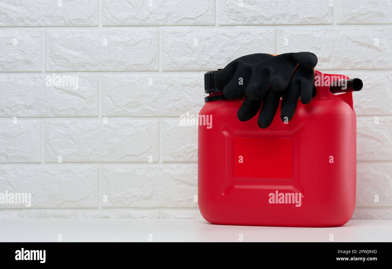 Red plastic canister for liquid fuels and lubricants on a white ...