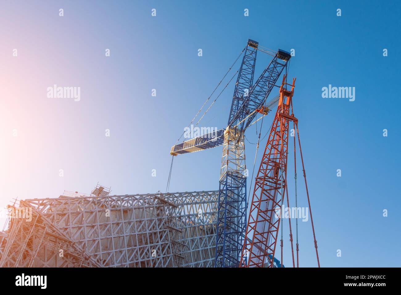 Metal crane and cables against the blue sky Stock Photo - Alamy