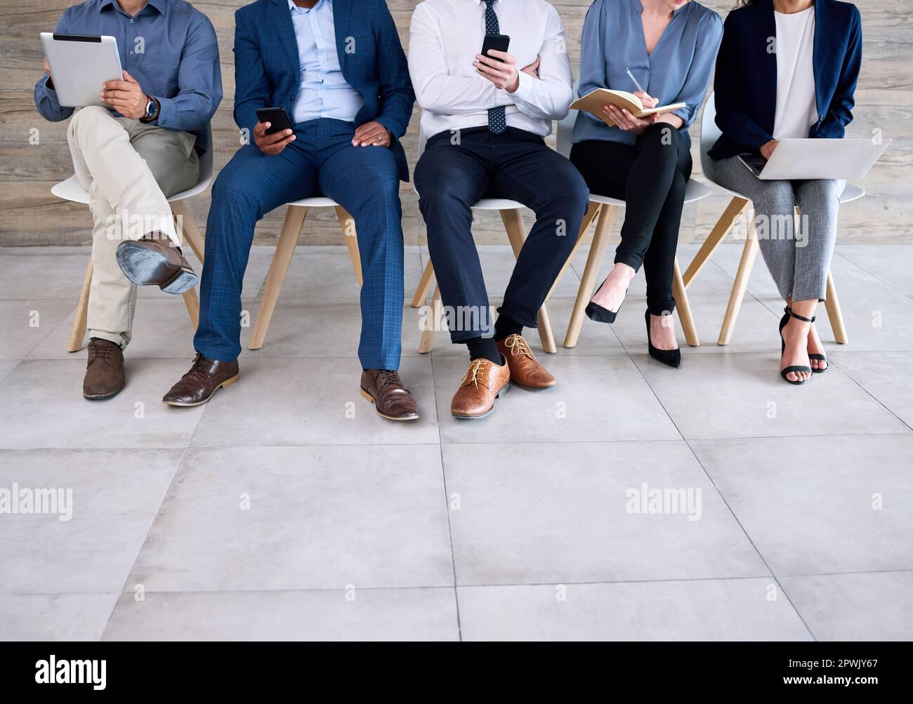 Lets all wait in line. a group of unrecognizable businesspeople sitting ...