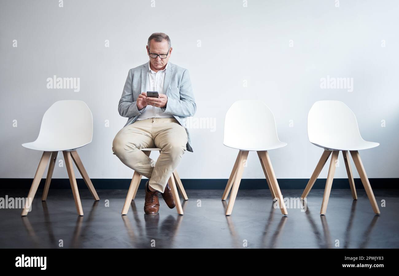 Last to leave. a young businessman waiting in line at an office Stock ...