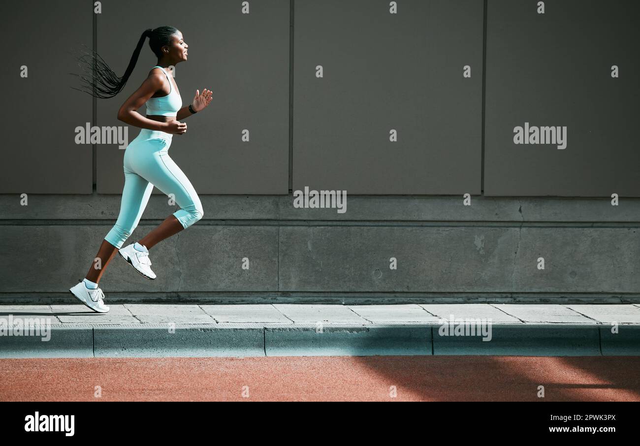 Keeping the destination in mind. a young woman running outside Stock ...