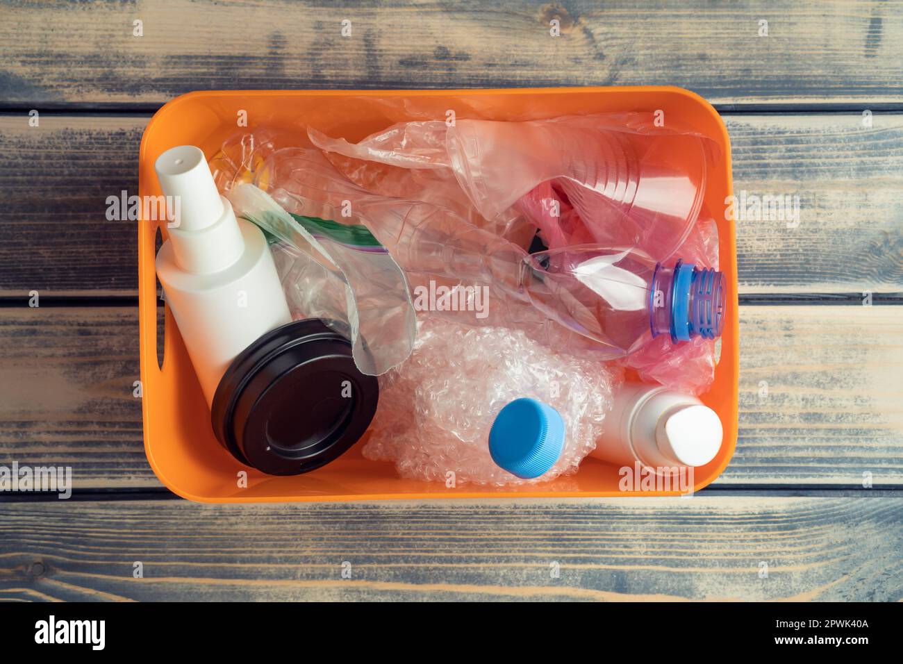 Orange plastic container box full of plastic jar, caps, pellicle and ...