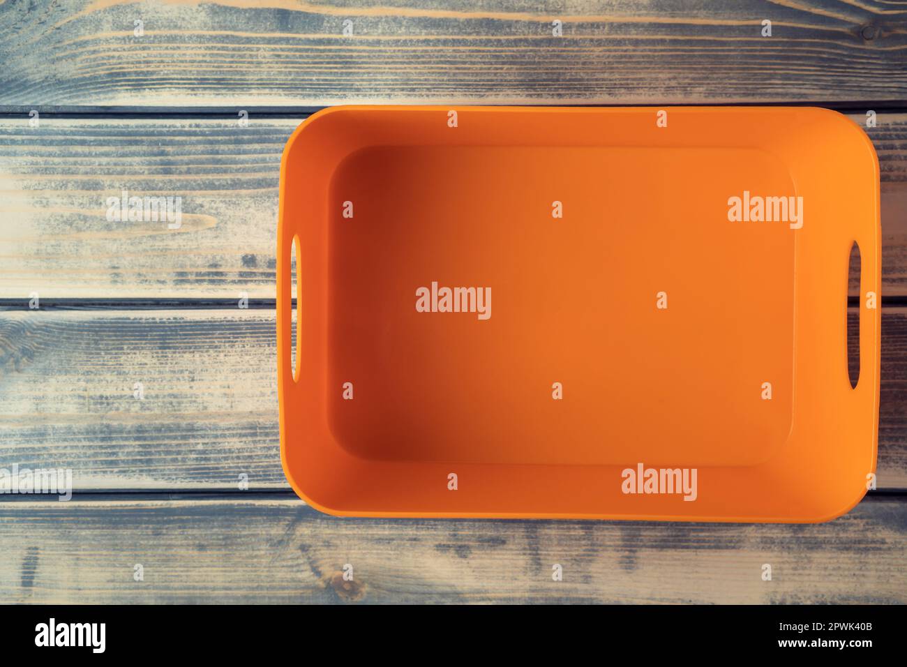 Orange empty plastic container, box on wooden table background ...