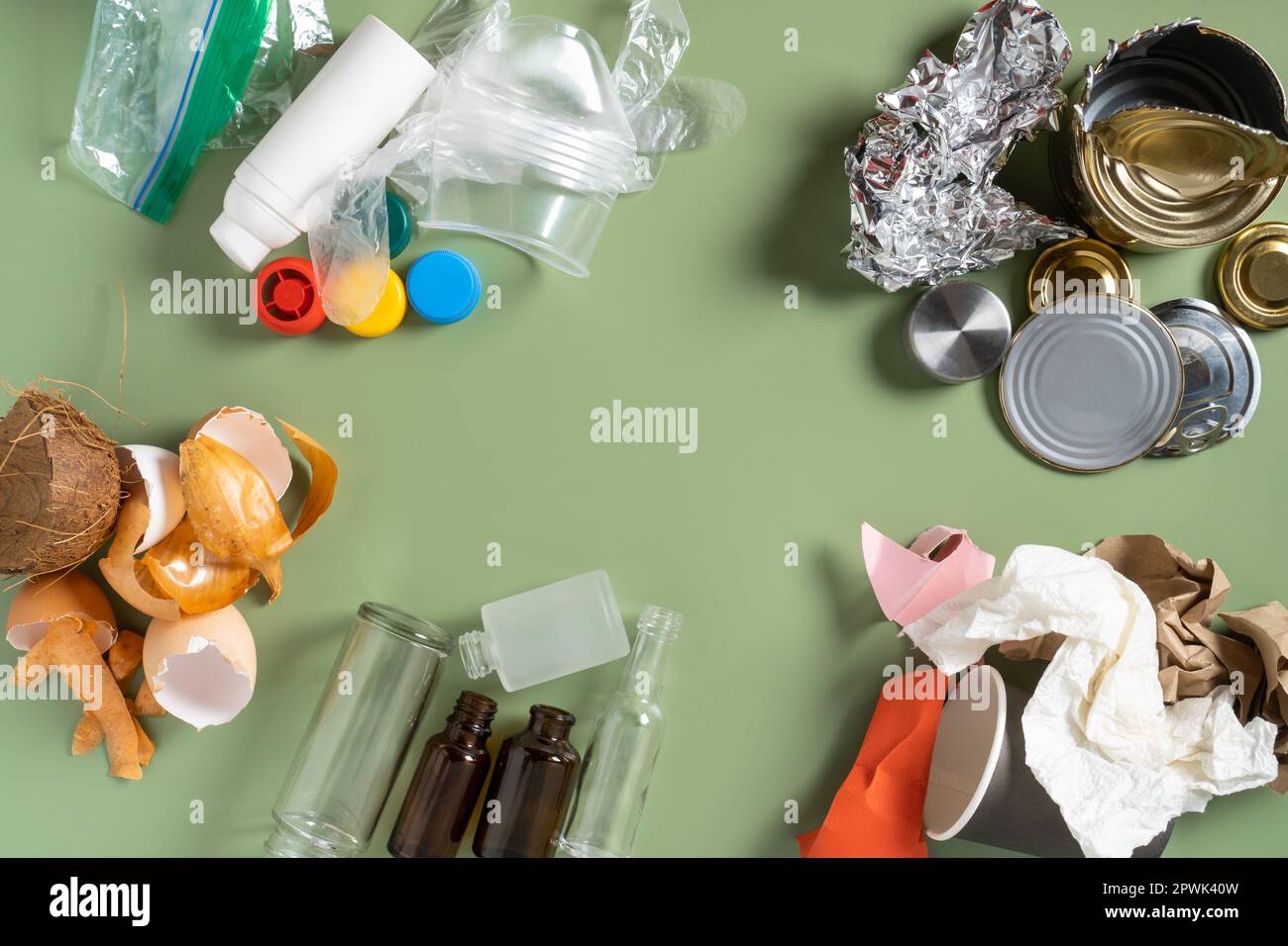 Different piles of waste of plastic, metal, organic food, paper, glass ...