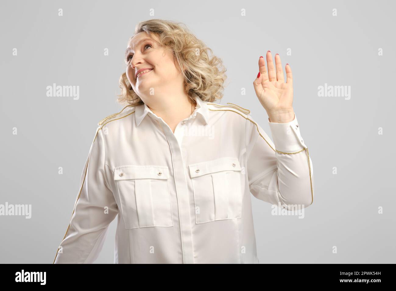 Senior woman waves her hand in disbelief over grey background Stock ...