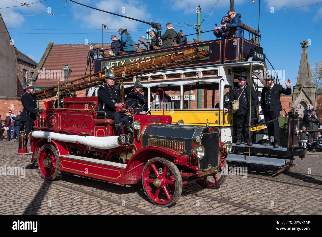 A vintage fire engine passes an equally vintage double decker tram car ...