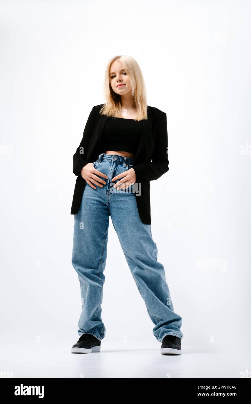 Teenager girl in tank top, jacket and jeans posing Stock Photo - Alamy