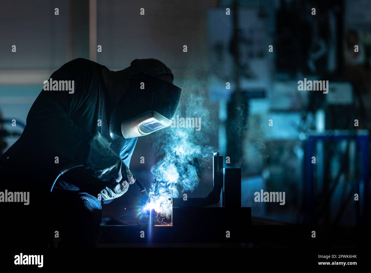 Man working on iron with grinder. Man at work. Sparkles and fire from ...