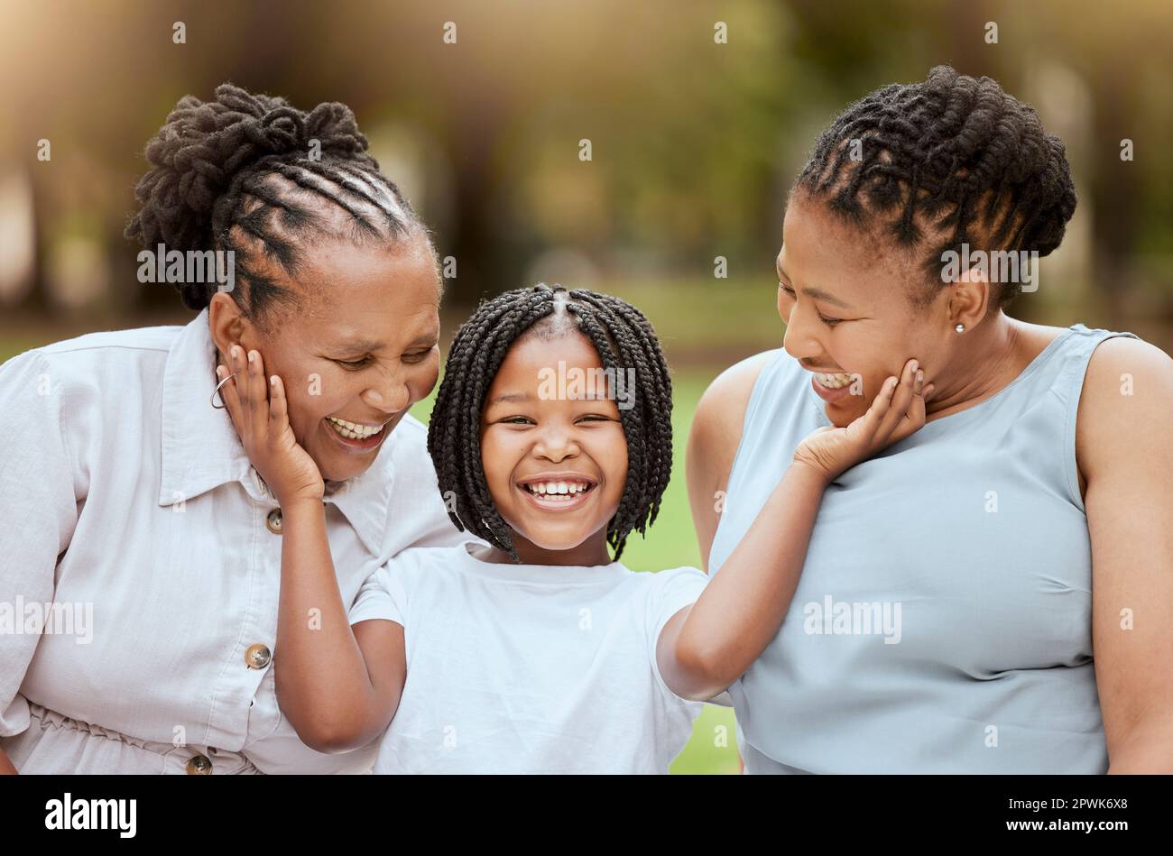Mother, grandmother and child in garden, happy family sitting on grass ...