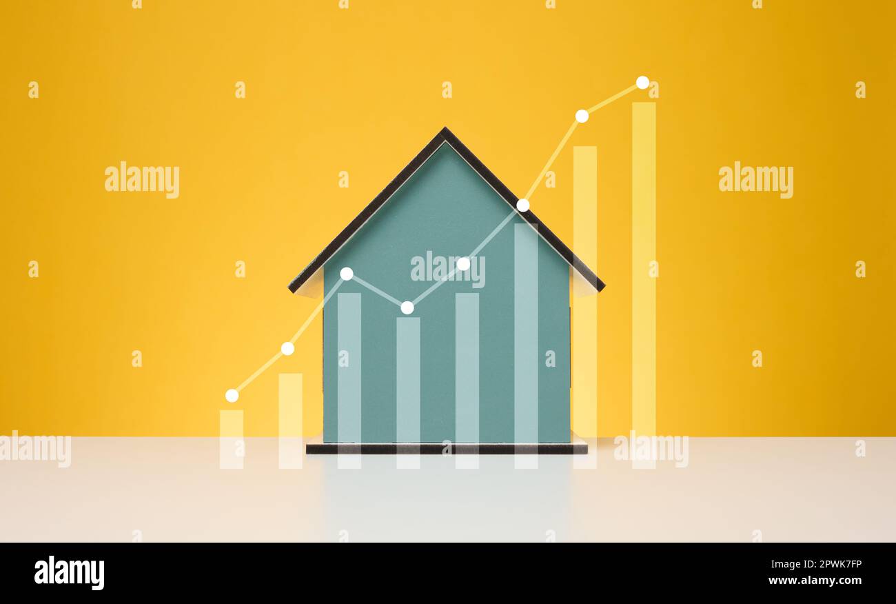 Wooden house and a graph with growing indicators. Rising property ...