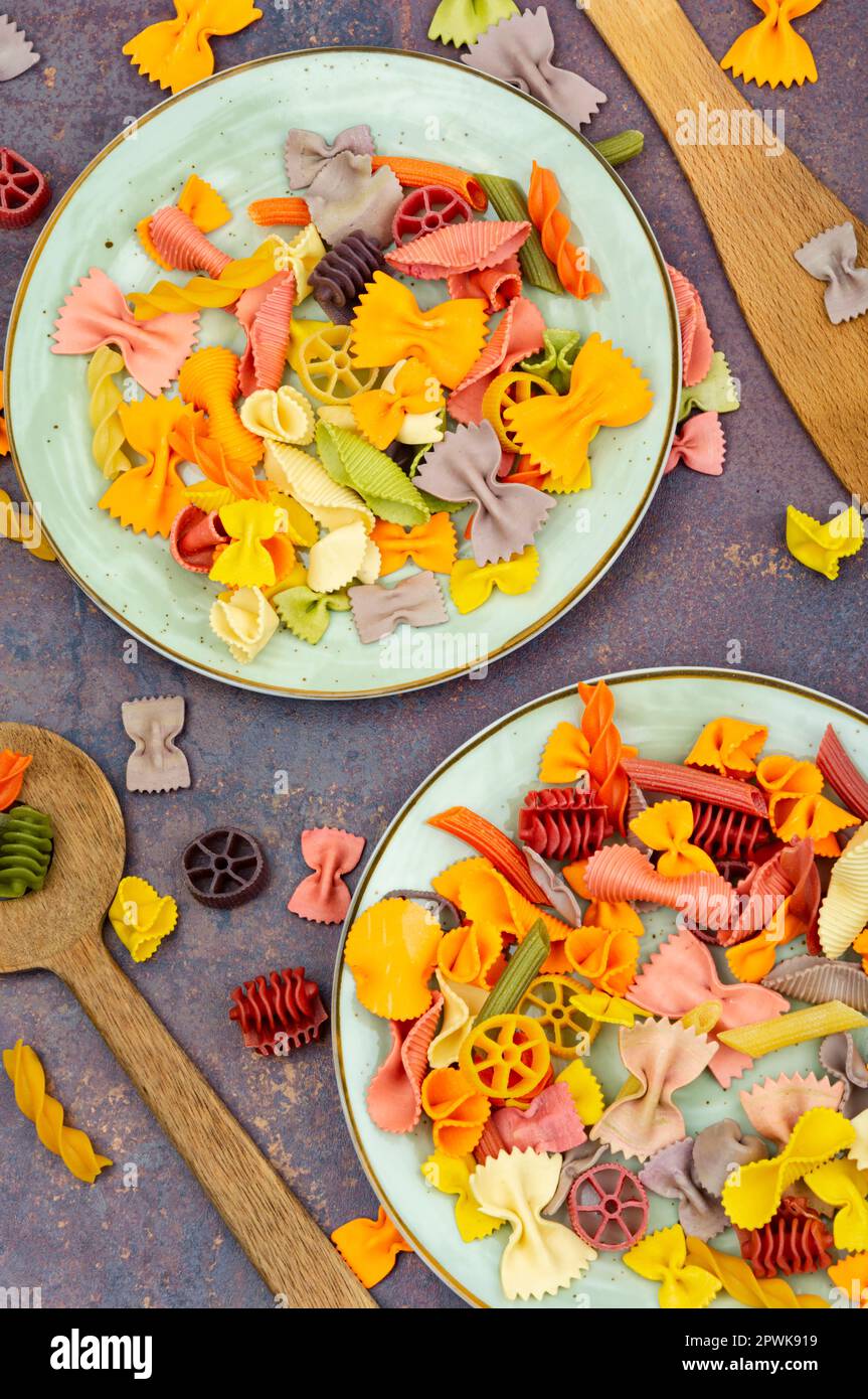 Colorful italian raw pasta on plate. Heap of colorful macaroni Stock ...
