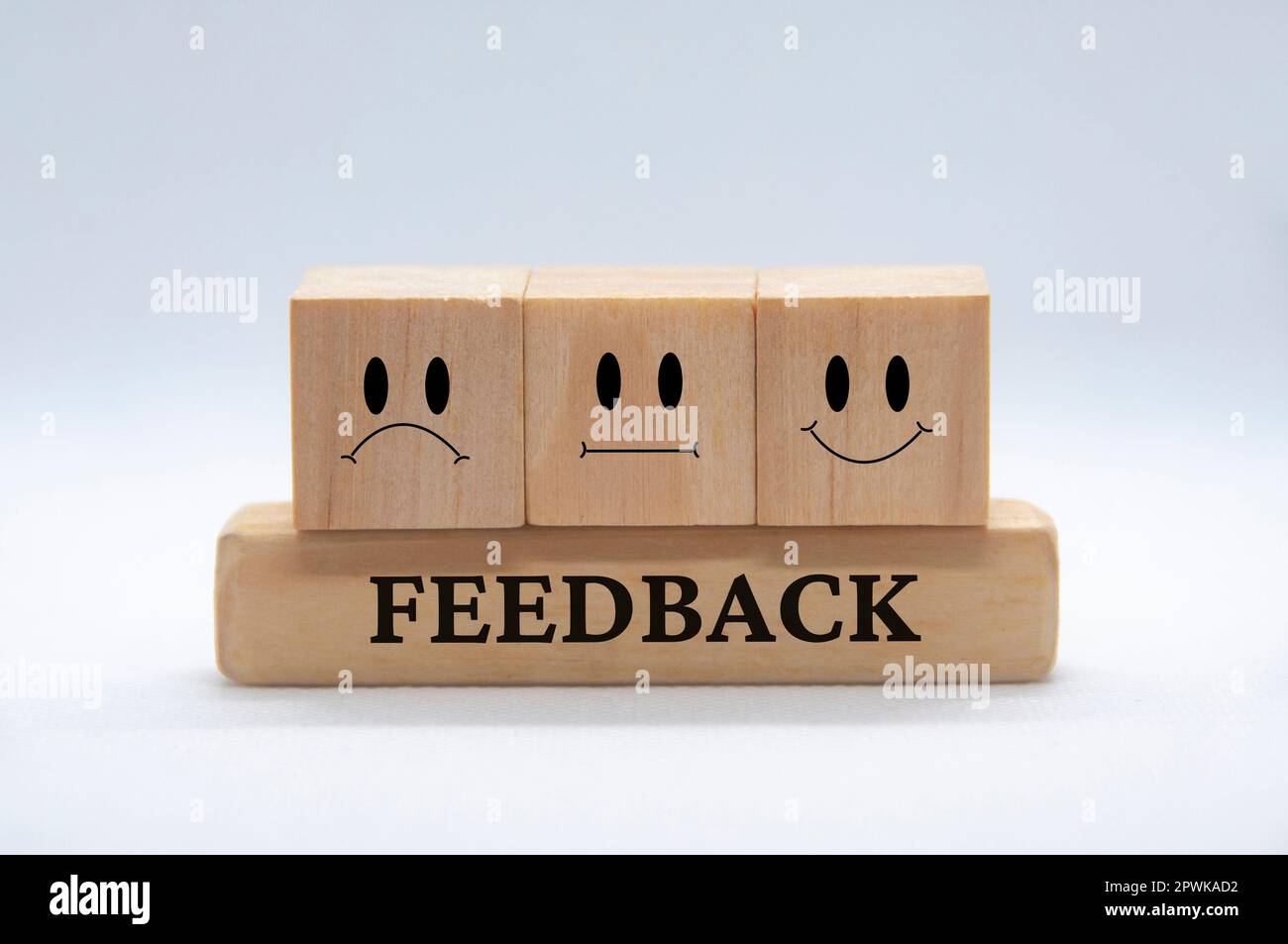 Sad, neutral and happy emotion faces on wooden cubes with white ...