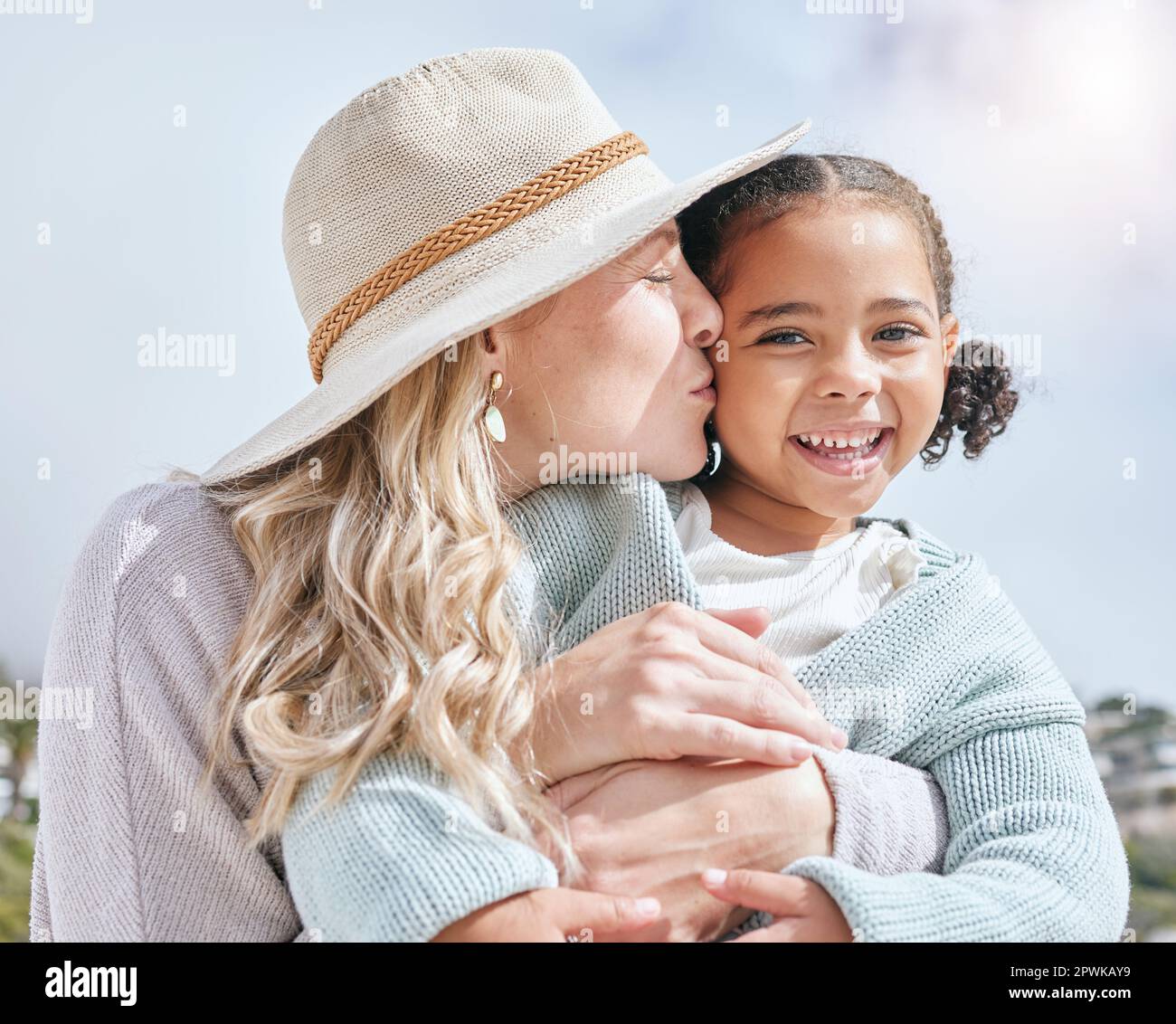 Mother kiss, girl and happy face of a mama and child adoption happiness ...