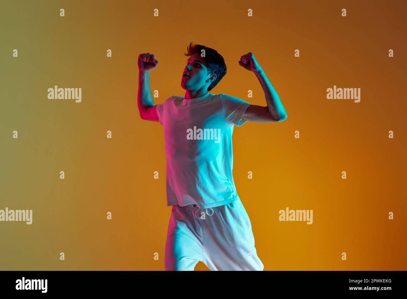 handsome guy dancing on yellow background. Neon lighting Stock Photo ...